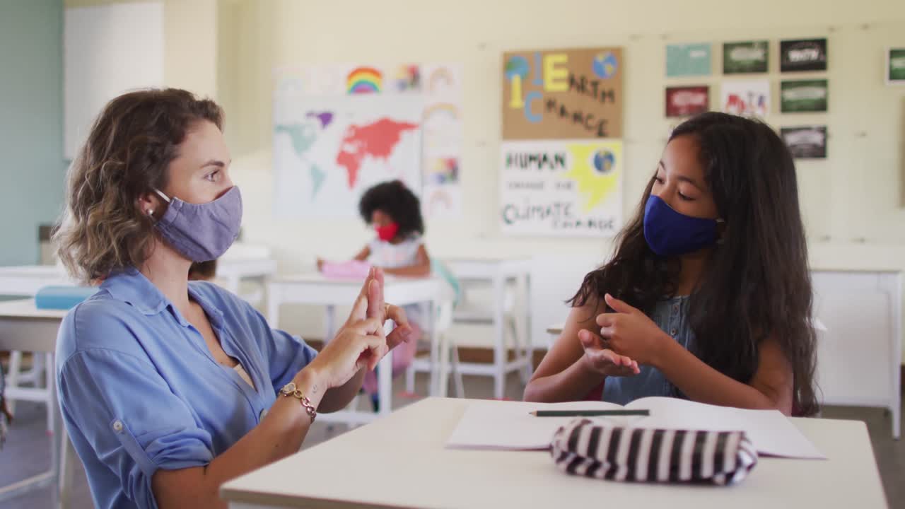 Female Teacher And Girl Wearing Face Masks Talking To Each Other ...