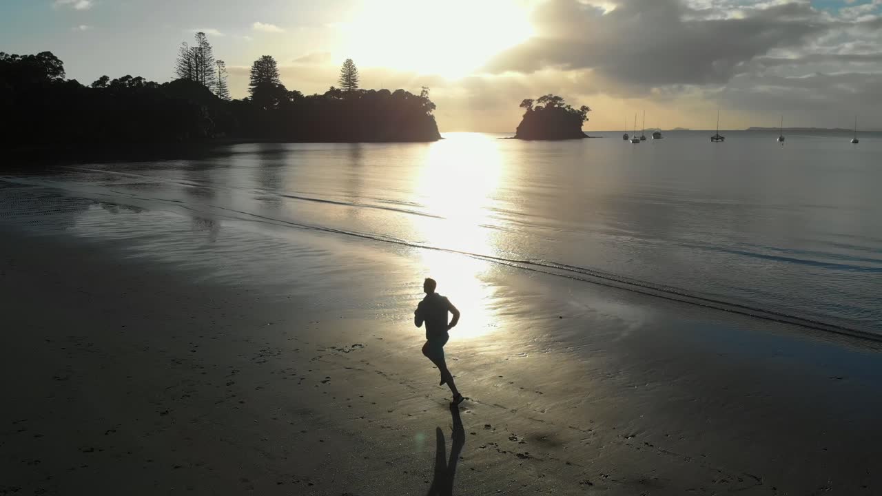Cinematic Aerial Tracking Shot Of Silhouetted Young Man Running On A ...