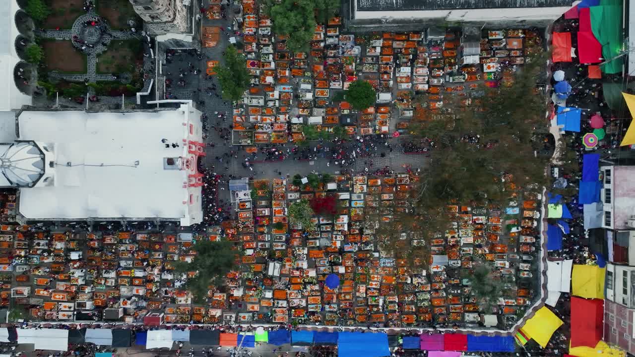 Aerial view over a church and a decorated graveyard, during all saints ...