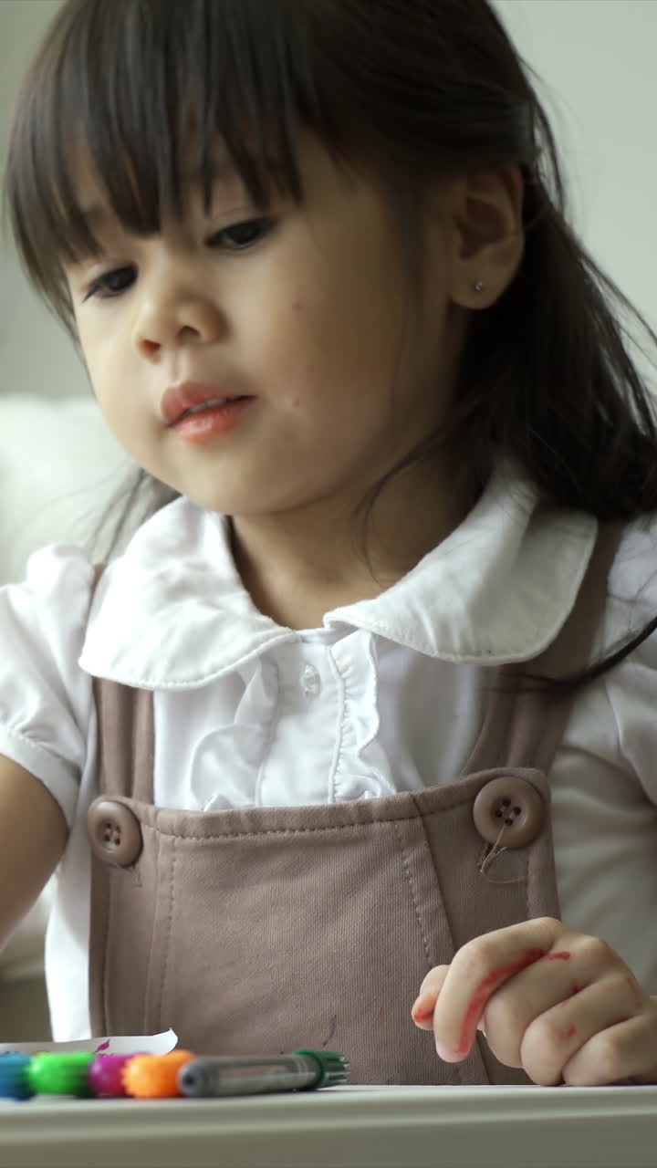 A young, asian child work and play at home learning to read and write ...