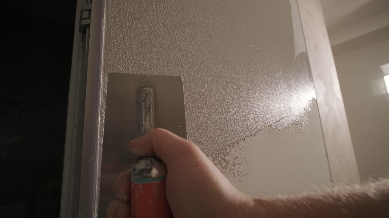 Worker applies decorative plaster with a thin spatula. Giving a unique ...
