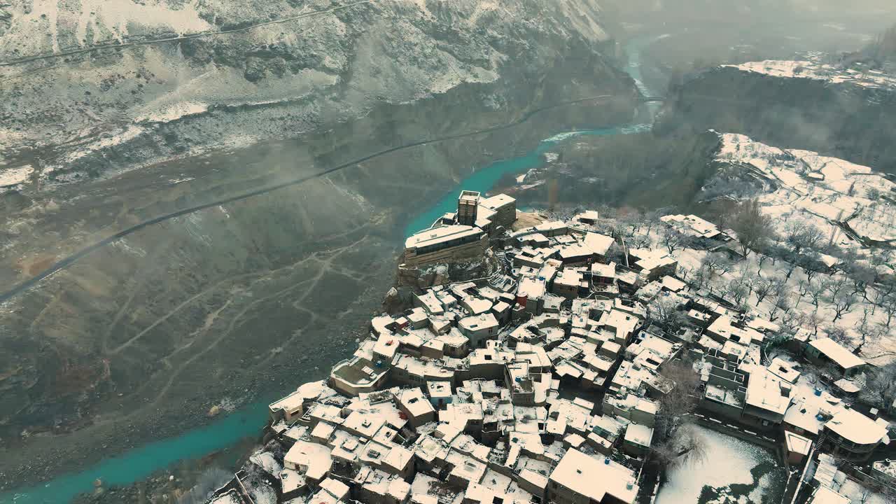 orbital aerial footage of a village hanging off a cliff in karimabad ...