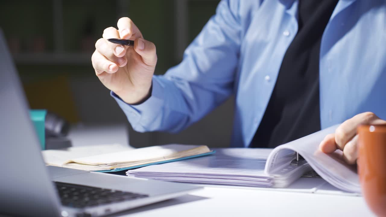Premium stock video - Home office worker examining files.