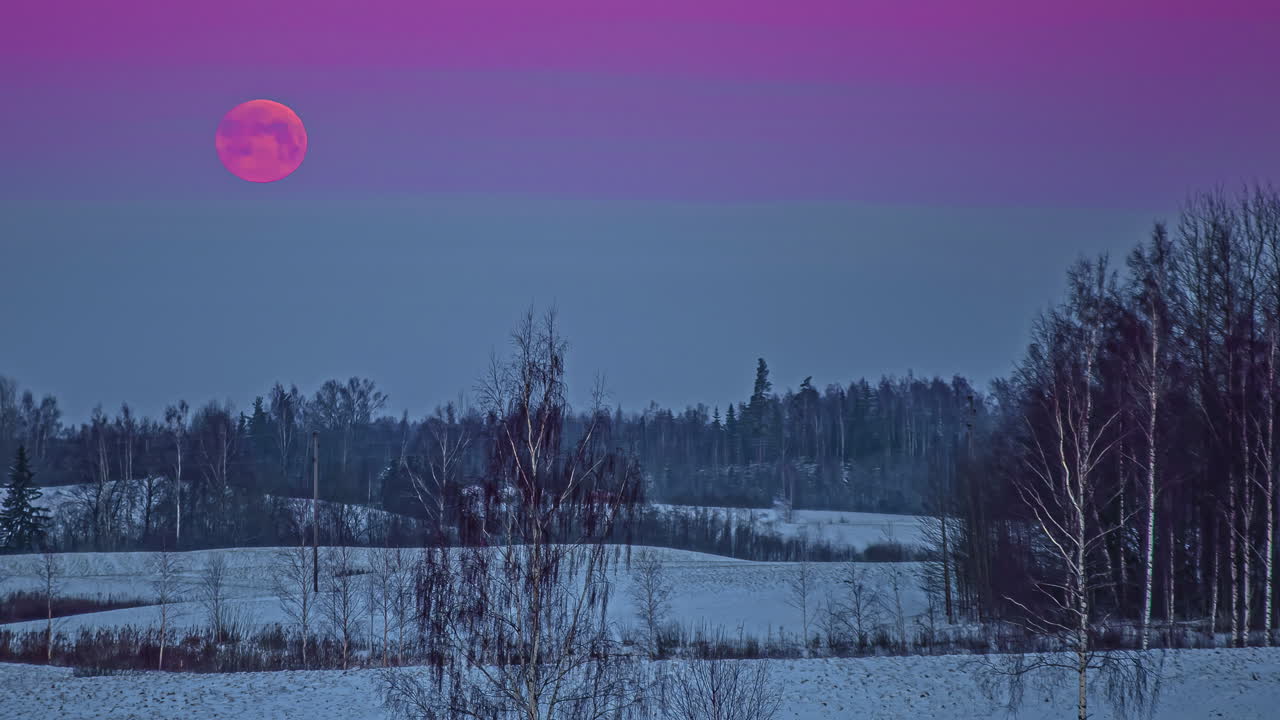 The Supermoon Sets Over A Winter Landscape Then Disappears In The ...