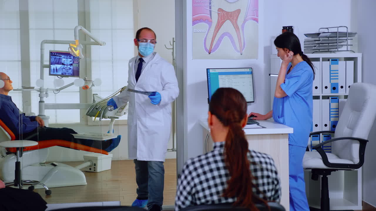 Dentist with protective mask giving teeth x-ray to nurse Premium Stock ...