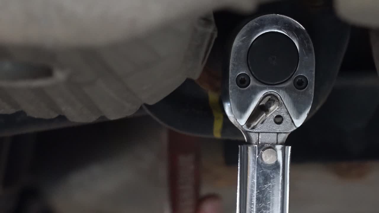 Premium 스톡 영상 - 차량 아래 볼트를 조이는 작업용 스패너