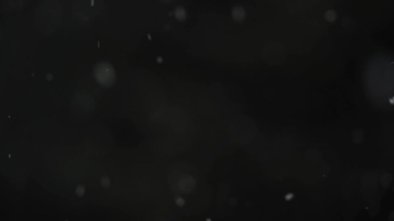 Premium stock video - Snow falling in slow motion with a dark blurry ...