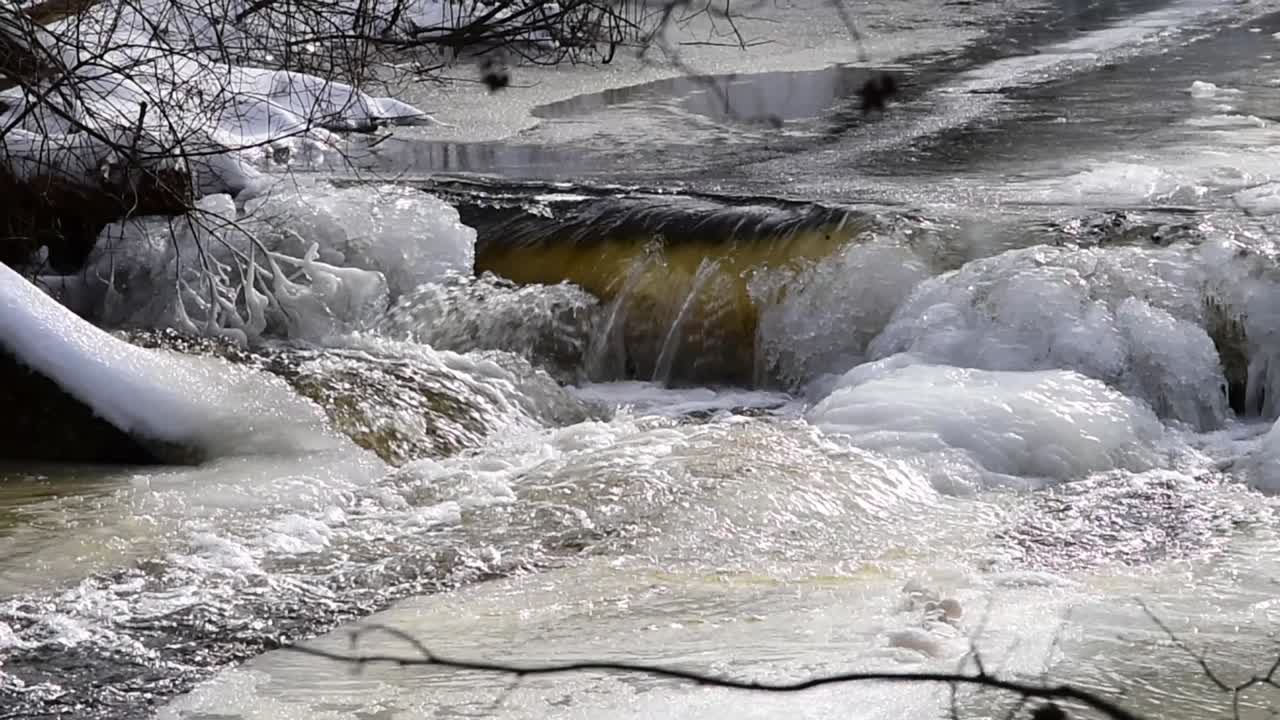 Premium stock video - Zoomed in view of frozen river falling over ice ...