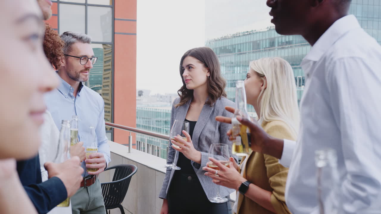 Premium stock video - Office colleagues socialising with drinks on a ...