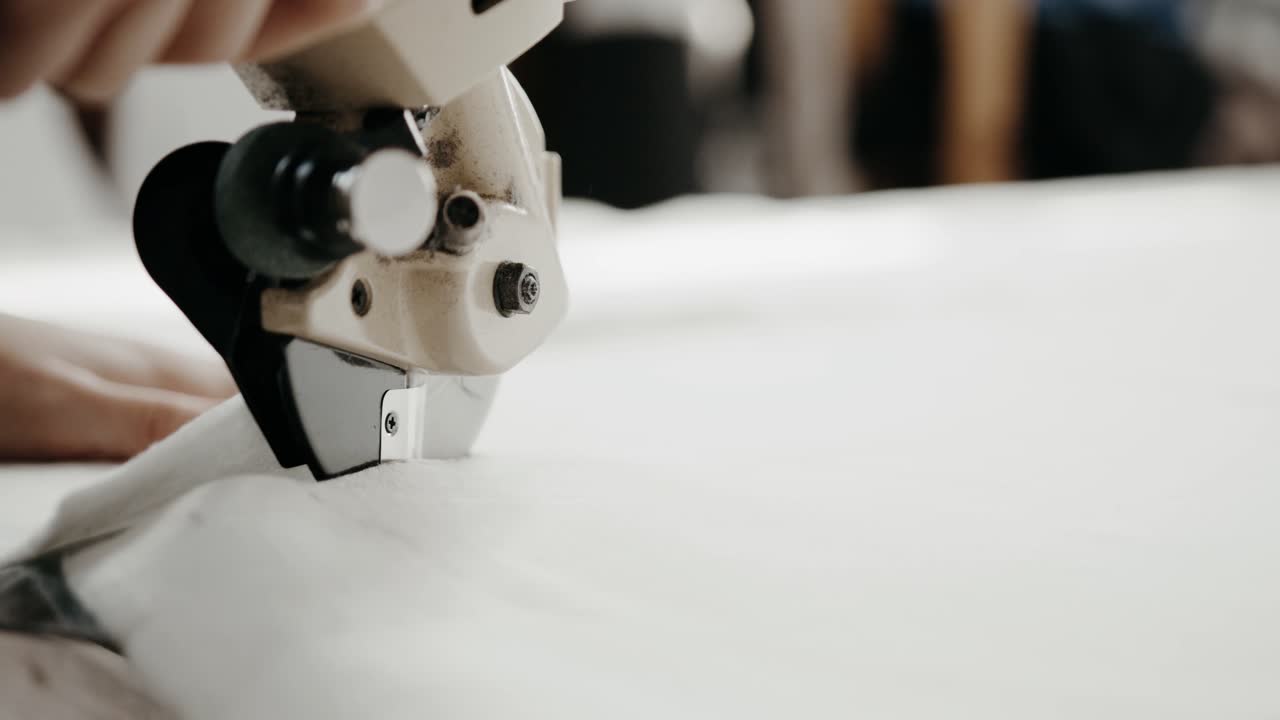 Hands Of A Seamstress Using A Fabric Cutter To Cut Out The Parts Of A ...