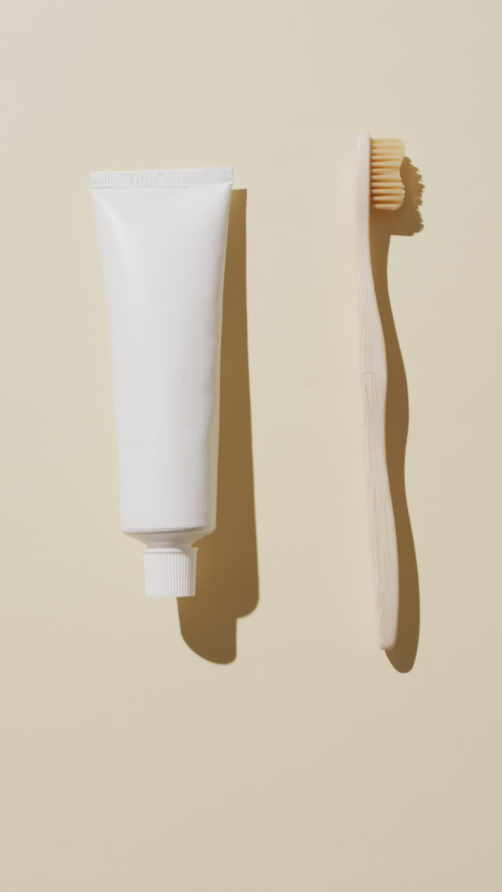 Vertical video of toothpaste and toothbrush on beige background ...
