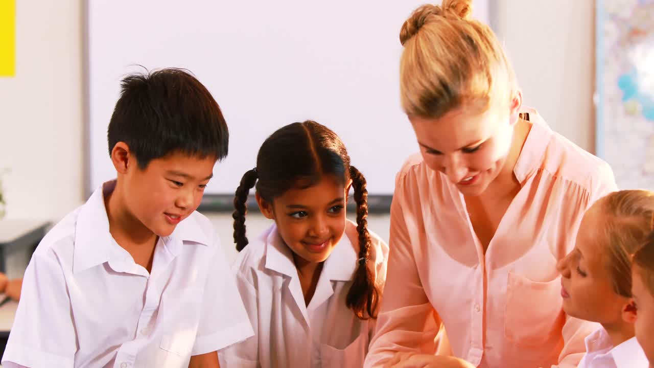 Premium stock video - Teacher teaching kids on digital tablet