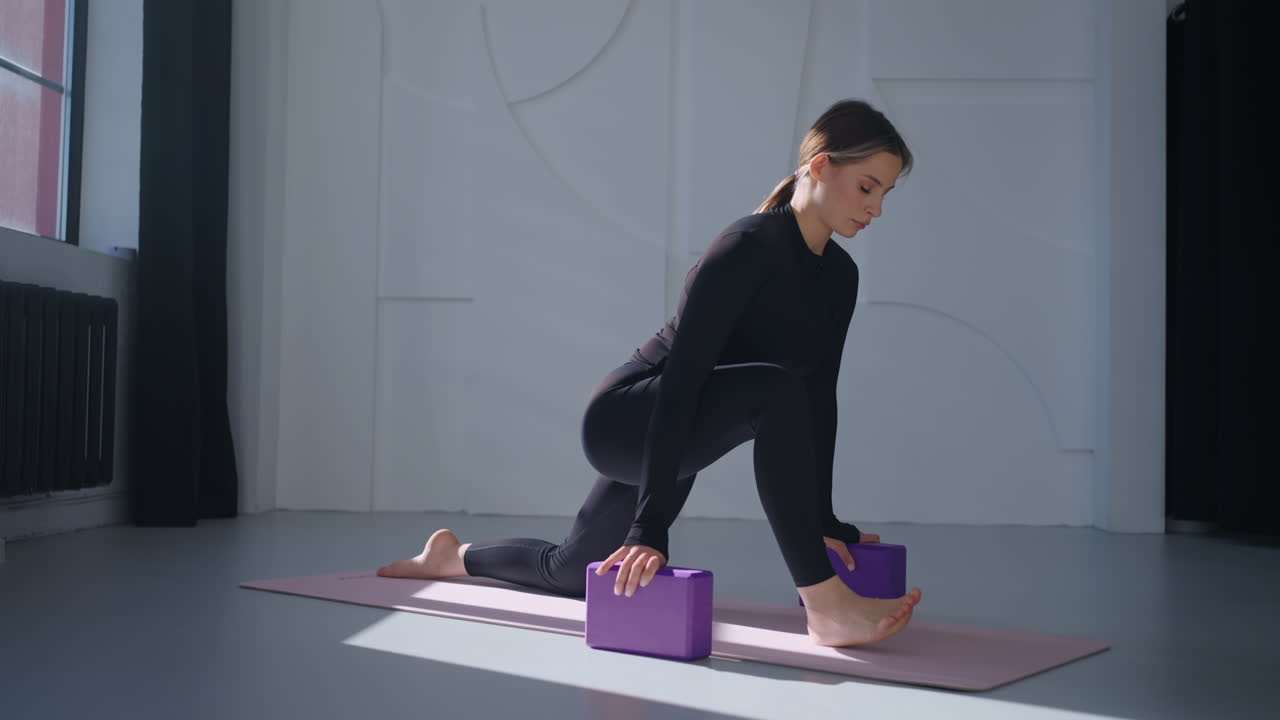 Woman doing yoga stretches using blocks Premium Stock Video Footage