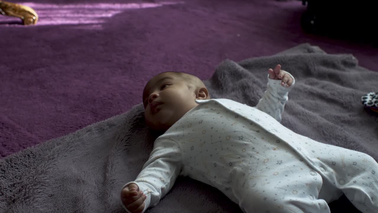 Adorable 2 month old bangladeshi baby boy wearing baby grow laying on ...