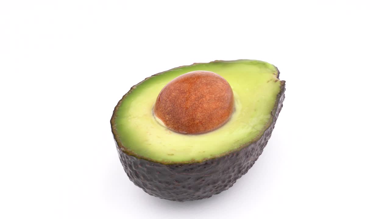 Avocado crudo en rodajas haas con una semilla gira lentamente en la ...