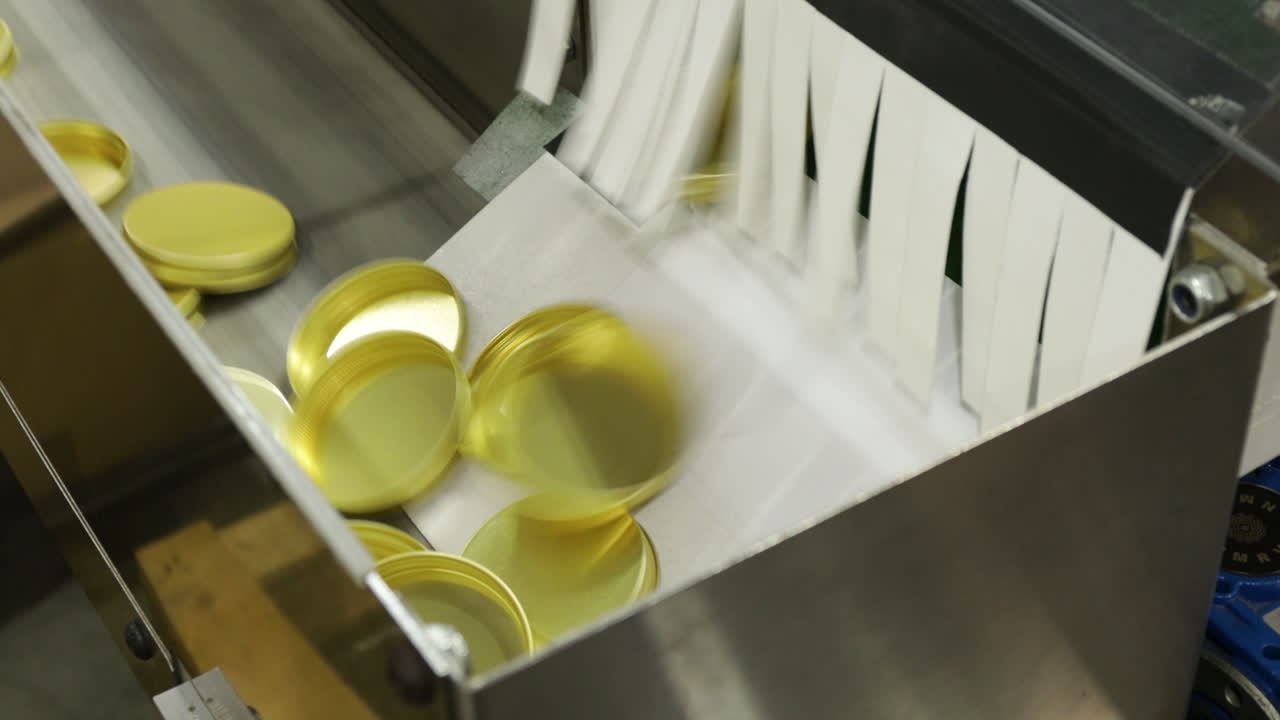 Premium stock video - Close up on automatic cap lining machine inside a ...