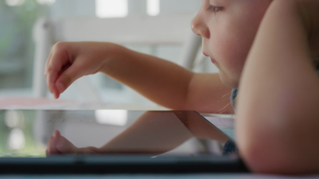 Premium stock video - Happy child using tablet computer little girl drawing pictures on ...