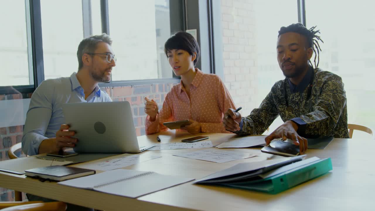 Premium stock video - Business executives discussing over laptop in ...