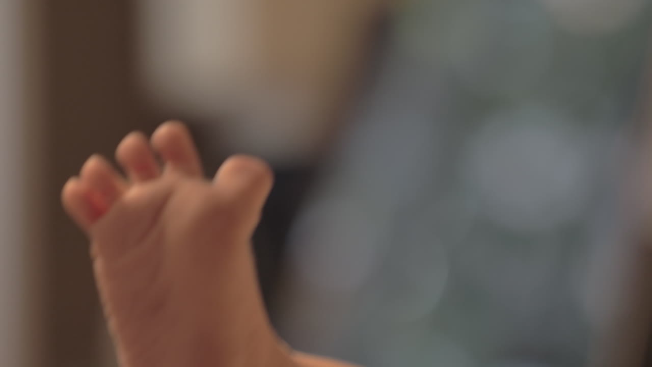 Premium stock video - Mum kissing the toes of newborn baby