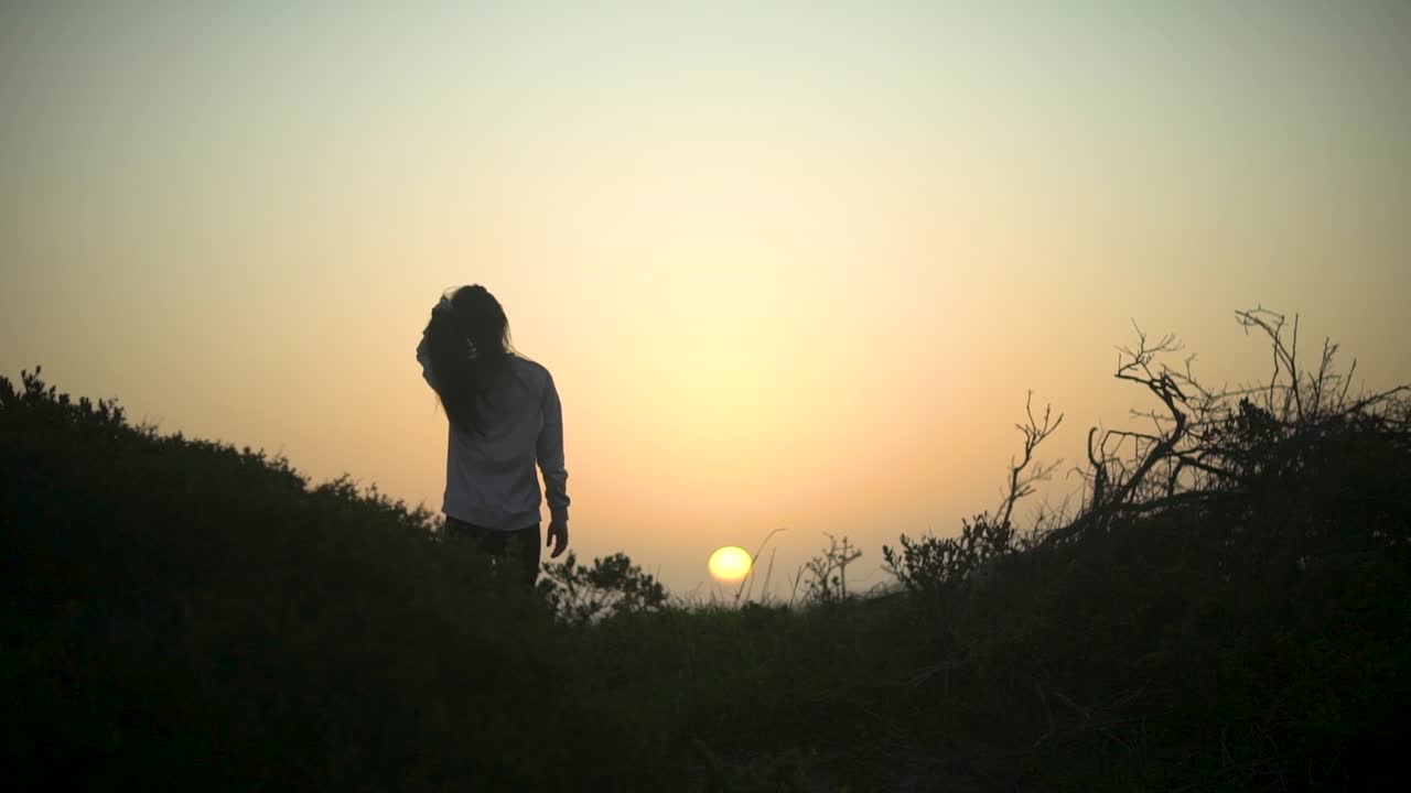 Premium stock video - Wide sunset shot of a girl in nature running ...