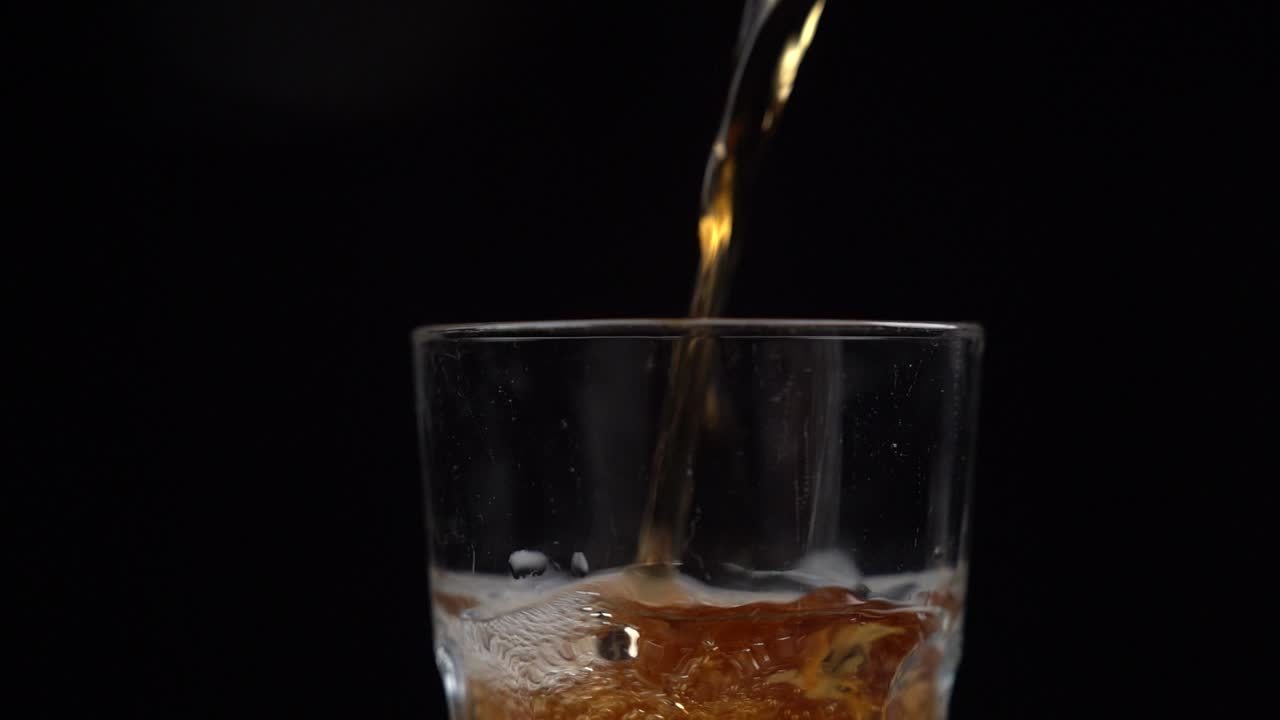 Premium stock video - Pouring carbonated iced tea into a glass with ...