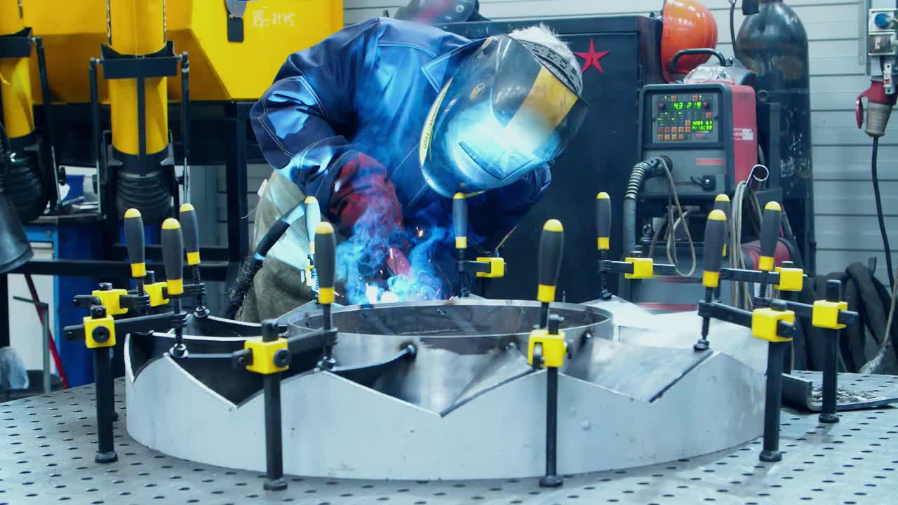 Worker in protective mask making weld of industrial unit. Welding ...