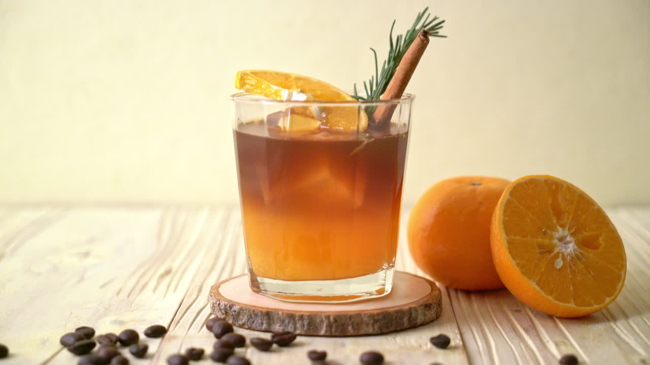A glass of iced americano black coffee and layer of orange and lemon ...