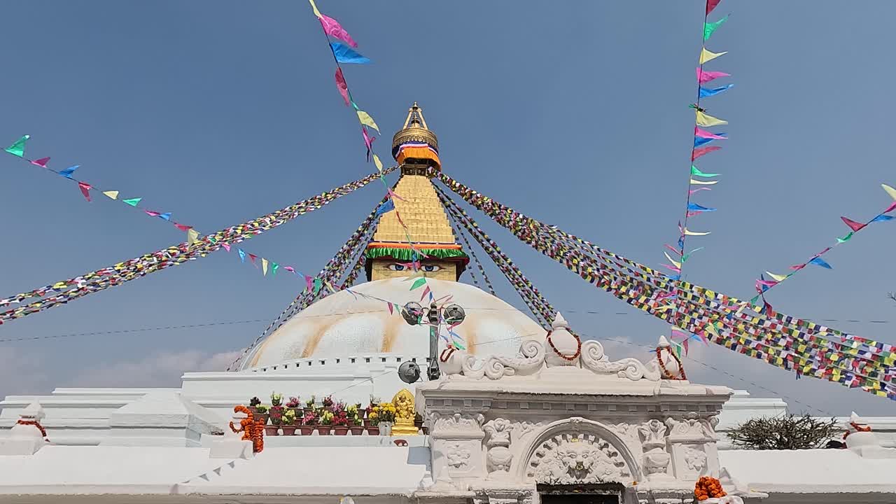 Premium stock video - Large emblematic stupa with eyes and prayer flags