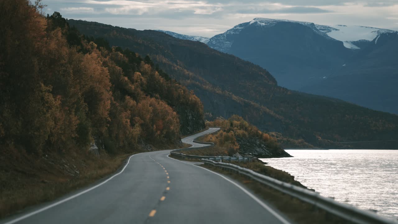 Premium stock video - Narrow two-lane road snaking along the fjord