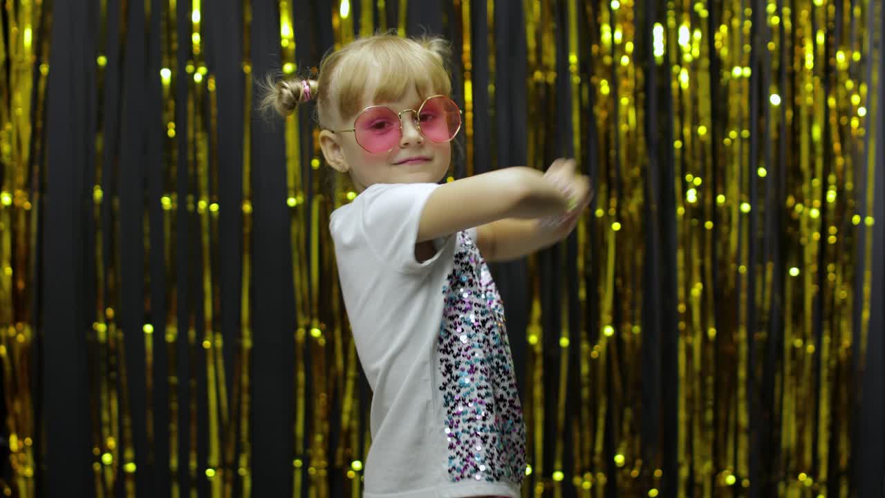 Child dancing, pointing fingers at camera. Girl posing on background ...