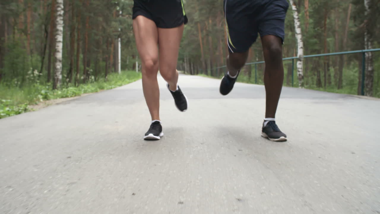 Man And Fit Young Woman Chatting And Running Along Forest Road In ...