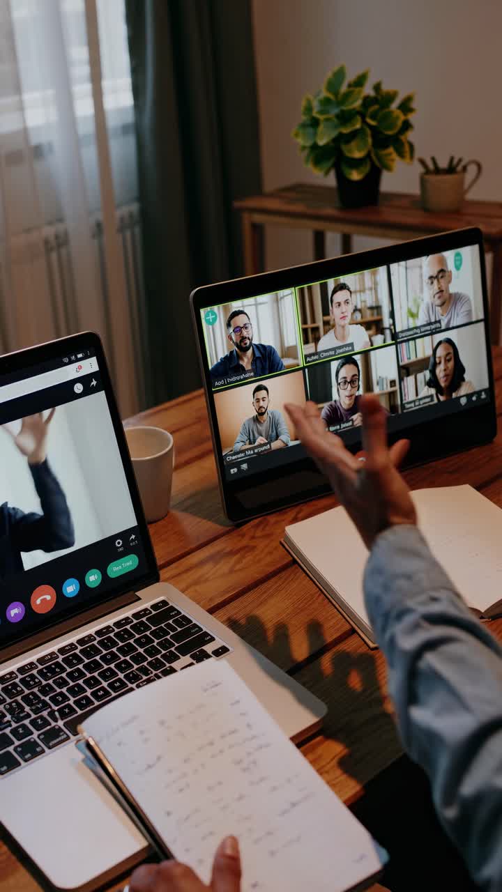 Overhead shot of a virtual meeting setup with two laptops on a wooden ...