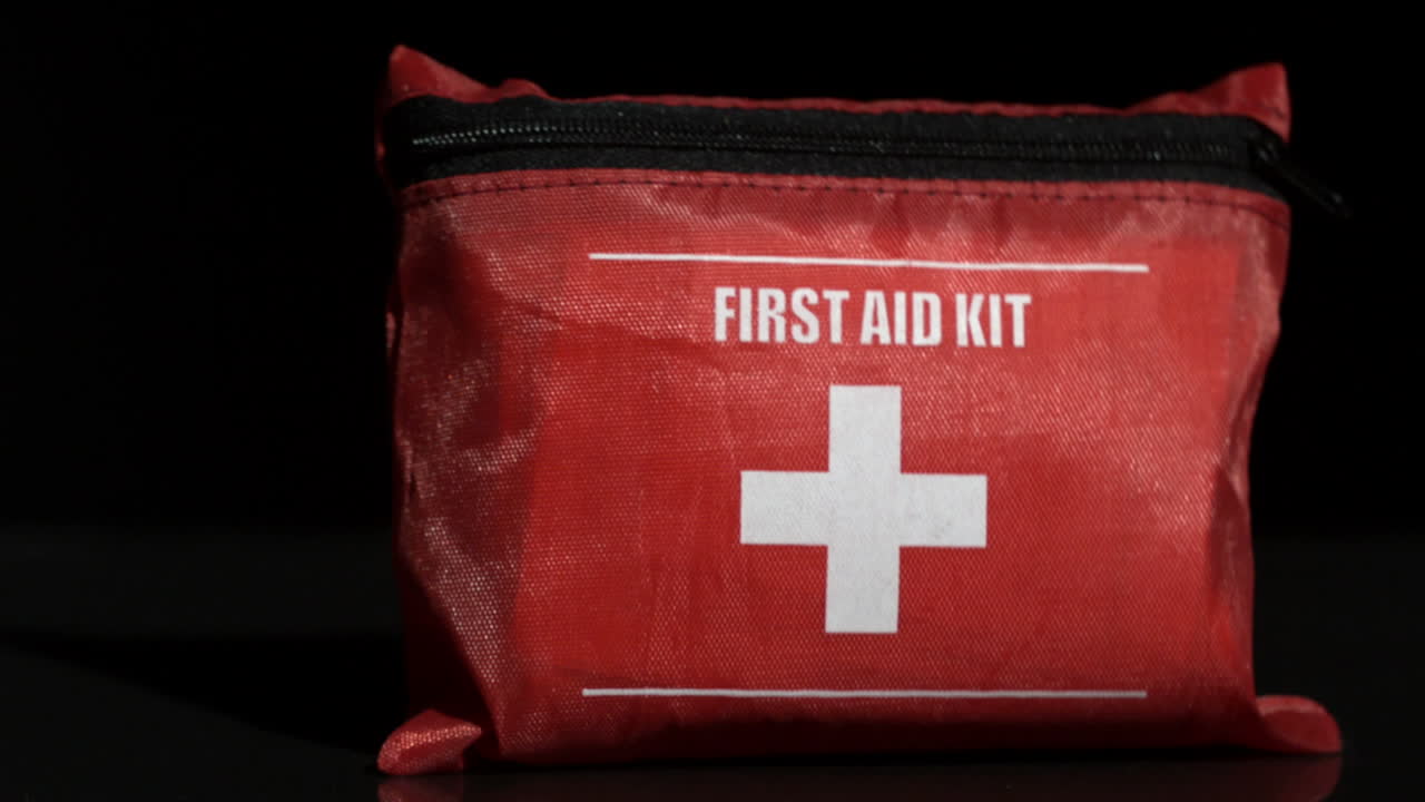 Premium stock video - First aid kit falling on black background