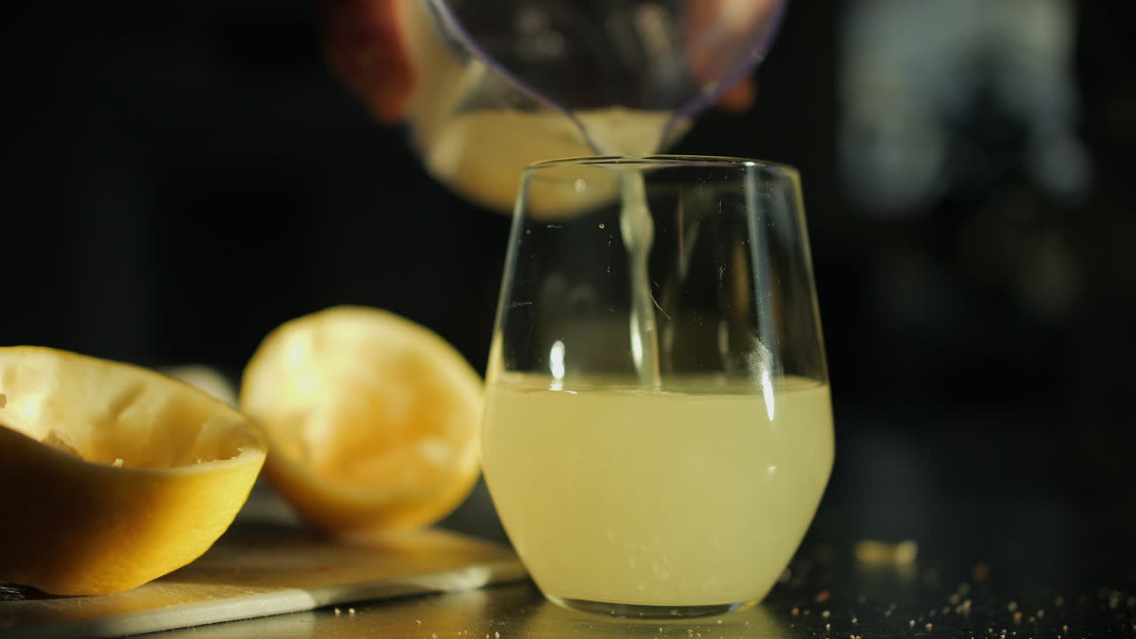 Premium stock video - Pouring freshly squeezed lemon juice into glass ...
