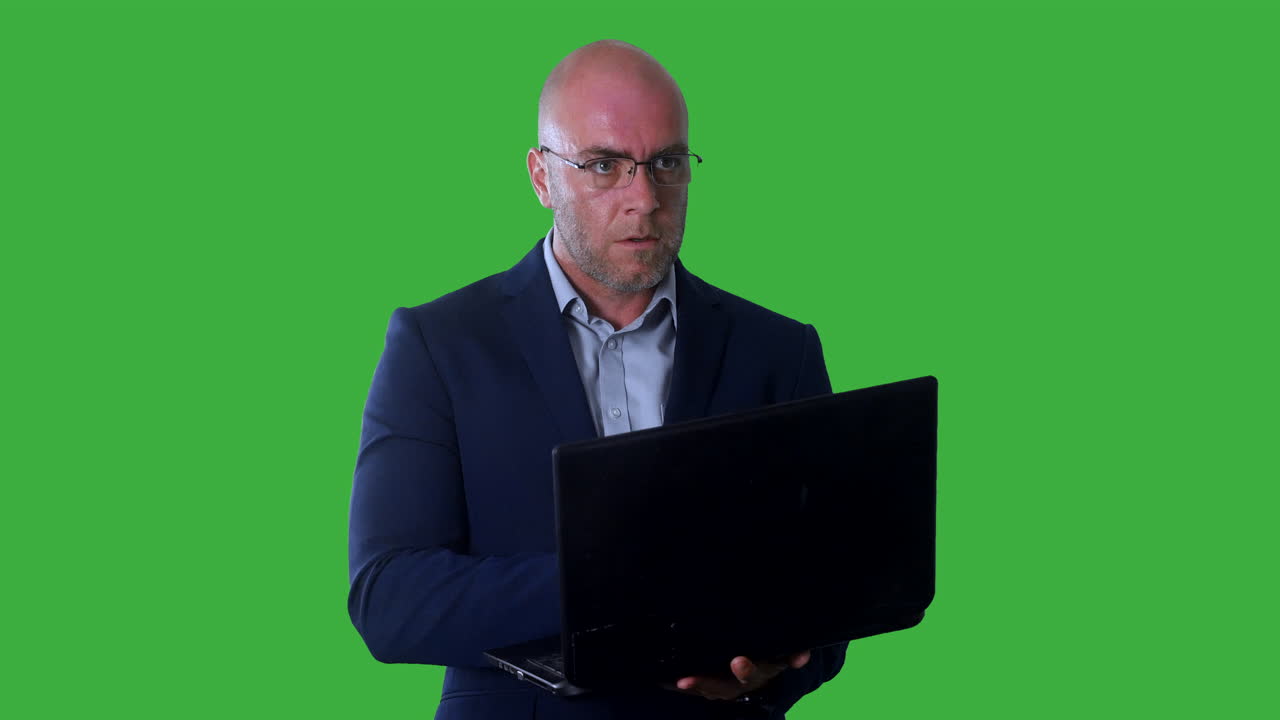 Premium stock video - A bald man typing and programming a laptop and ...