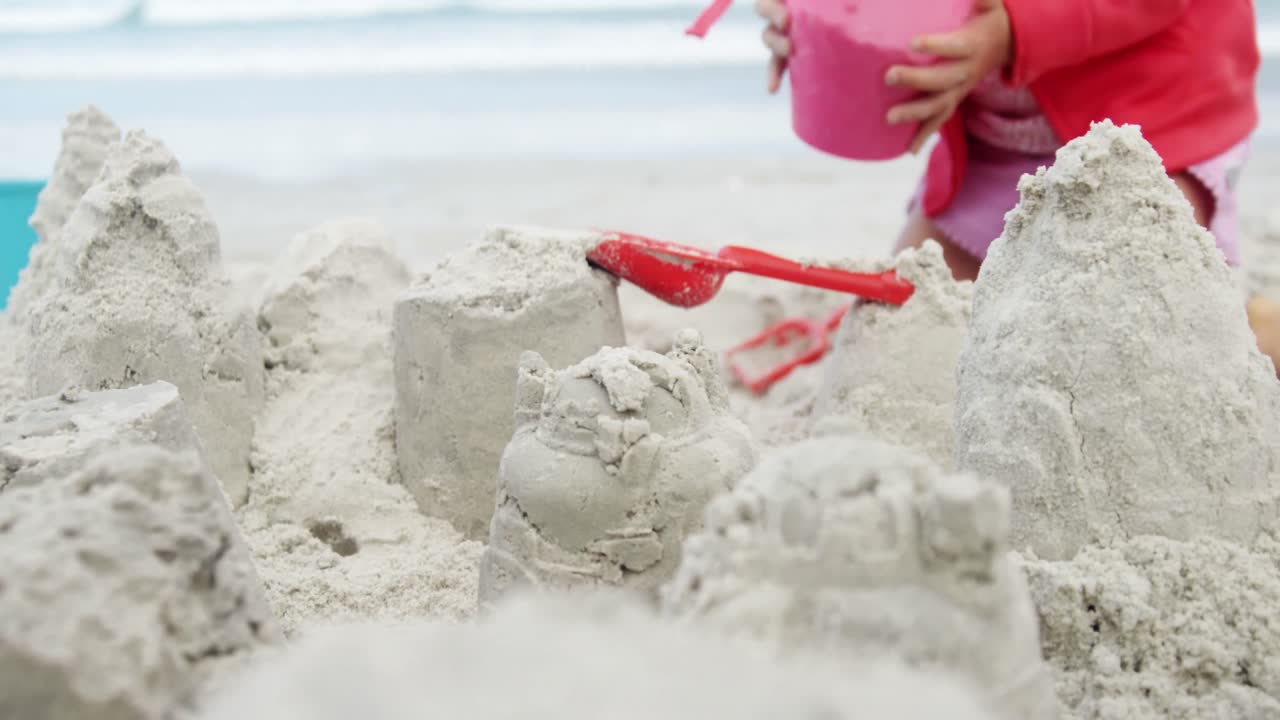 Premium stock video - Girl making making sand castle at beach