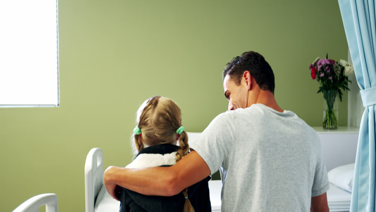 Father and daughter sitting on medical bed in hospital | Free Stock ...