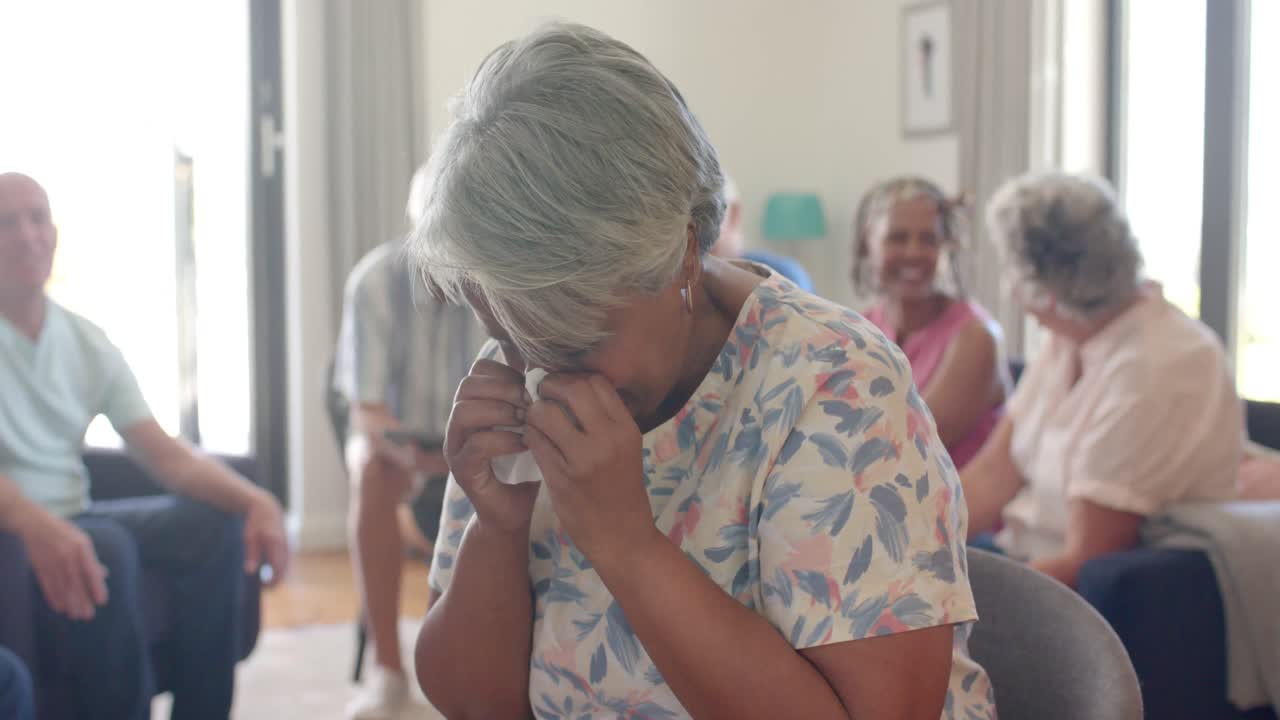 Distressed diverse seniors crying and talking in group therapy session ...