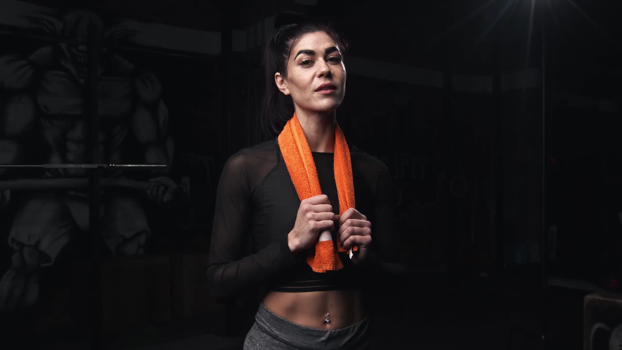 Premium stock video - Young woman posing after workout in the gym ...