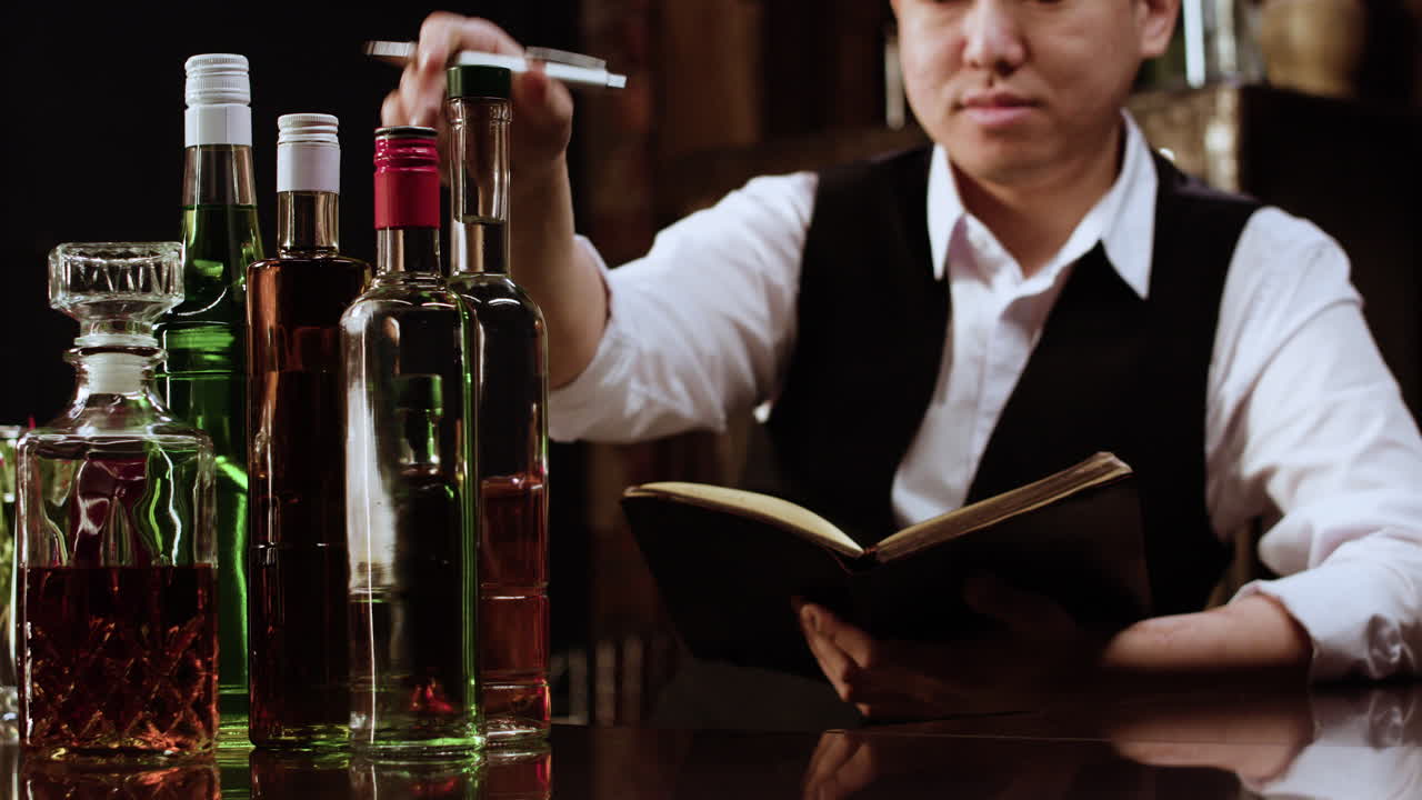 Free stock video - Bartender checking alcohol bottles