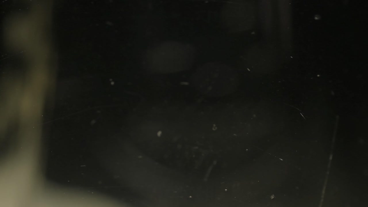 Pouring yellow fizzy liquid into a glass with a black background in ...