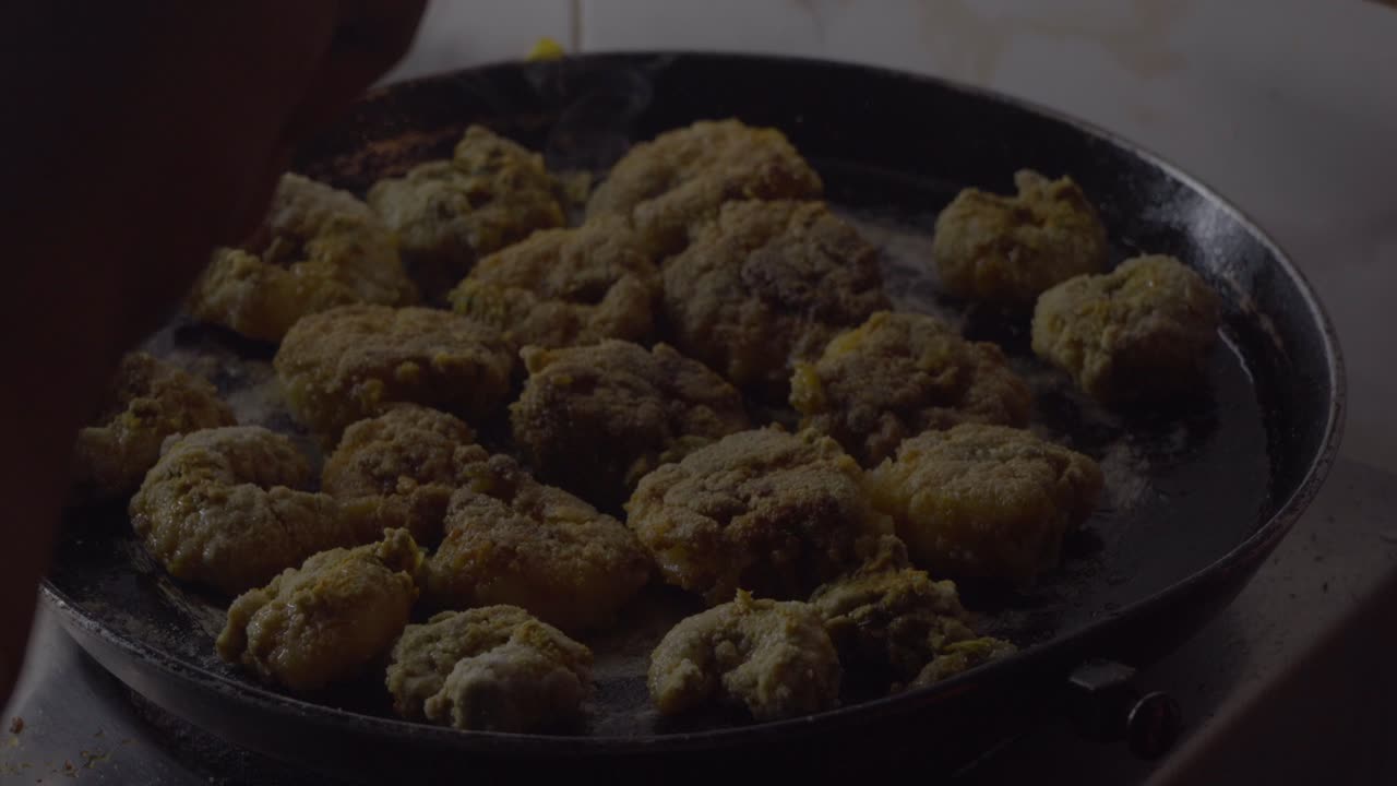 Premium stock video - Indian women hand fring rawa prawns in black hot pan