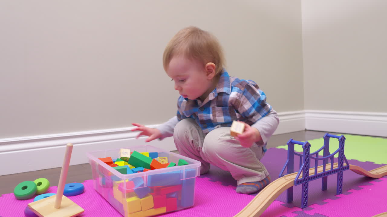 Premium stock video - Cute toddler boy exploring the toys in his playroom