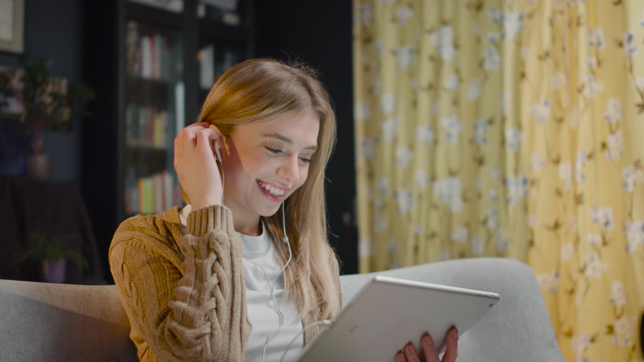 Happy Young Woman With Earphones Watching Funny Video On Tablet While ...