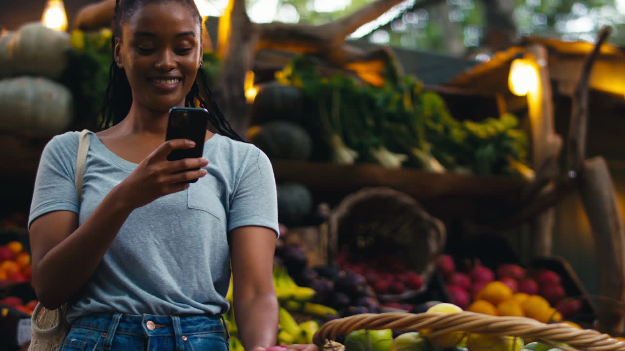 Une cliente au stand du marché prenant une photo de produits frais sur ...