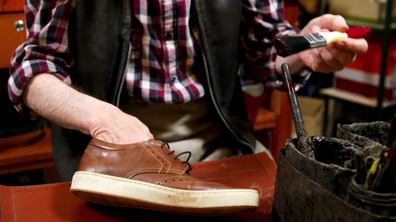 Shoemaker painting on a shoe Premium Stock Video Footage