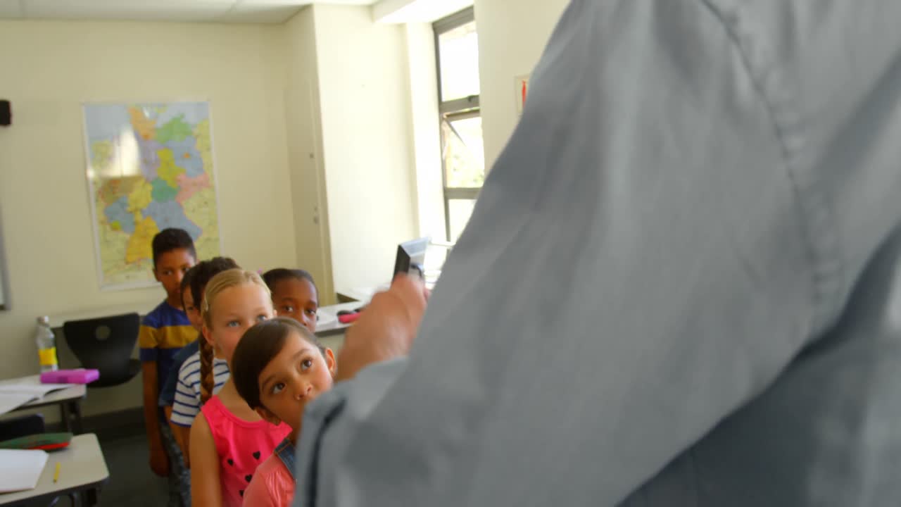 Caucasian Male Teacher Teaching Schoolkids In A Classroom At School 4k ...