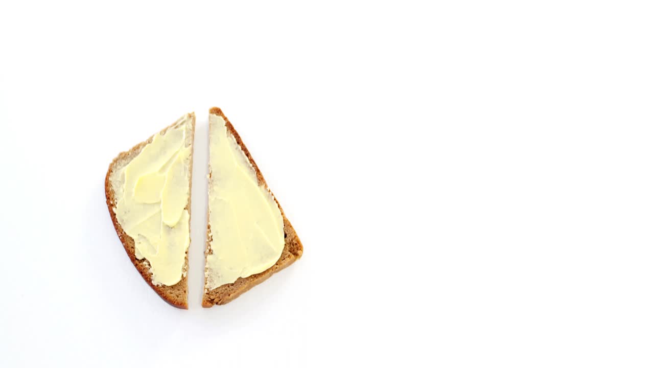 Premium stock video - Butter spread on bread slice