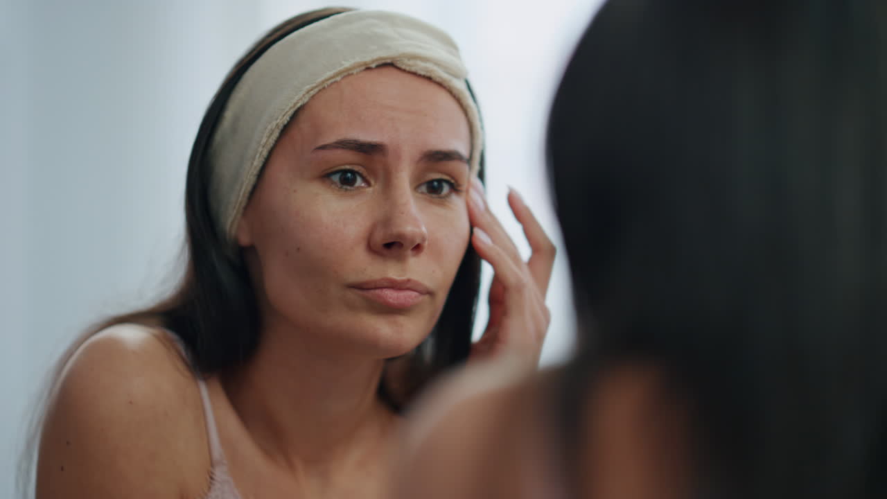Frustrated model touching skin looking mirror reflection. Lady first ...