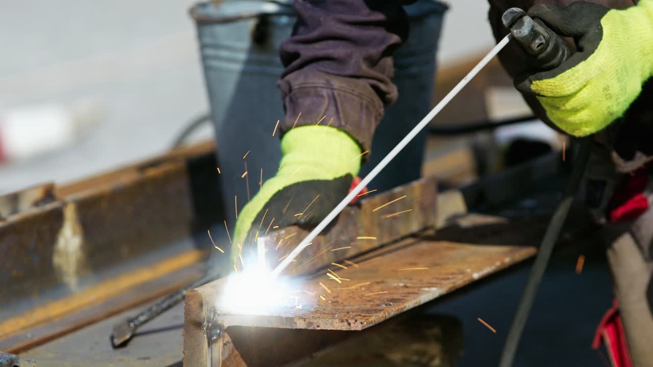 Welding sparks flare from steel beam in close-up slow motion static ...